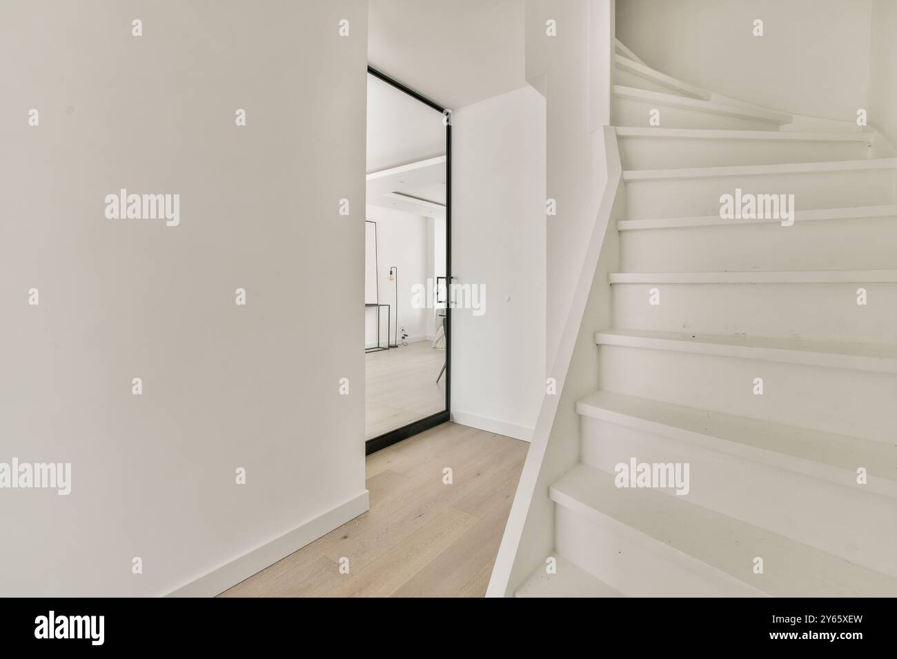 A contemporary home interior showcasing a minimalist white staircase ...