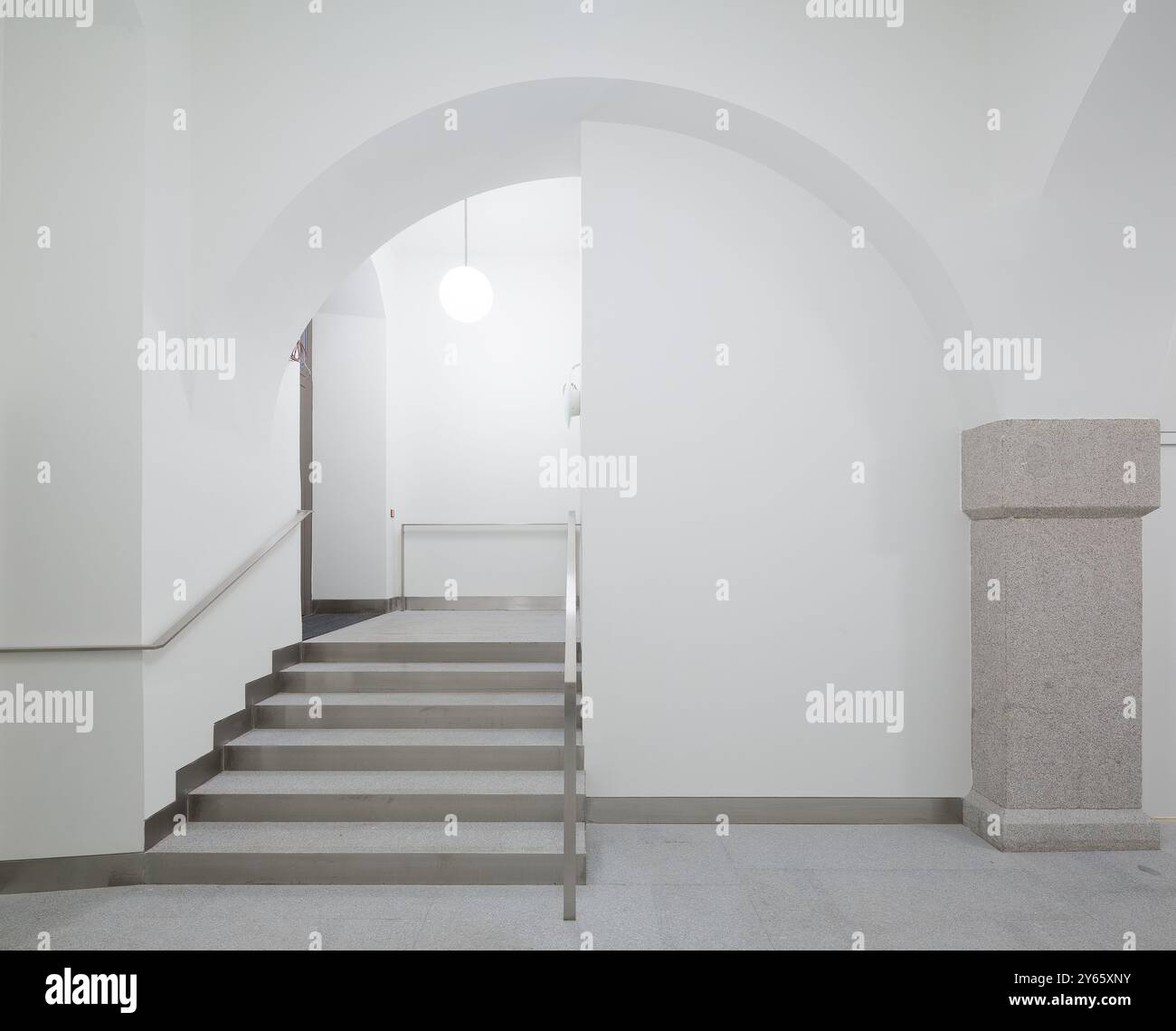 An architecturally simple staircase in an office setting, flanked by ...