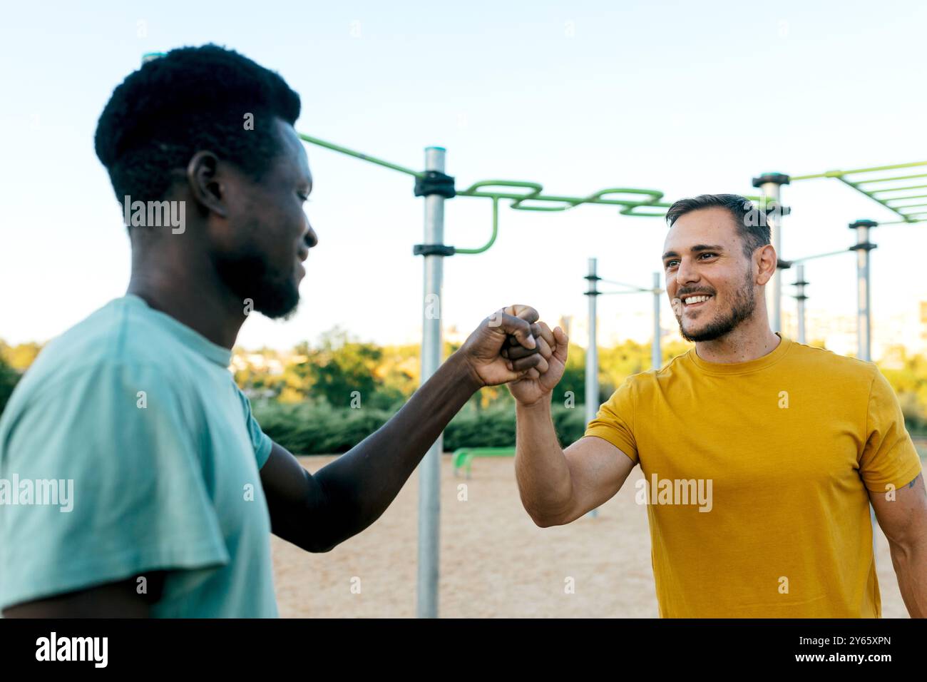 Two friends fist bumping with smiles, displaying camaraderie during a ...