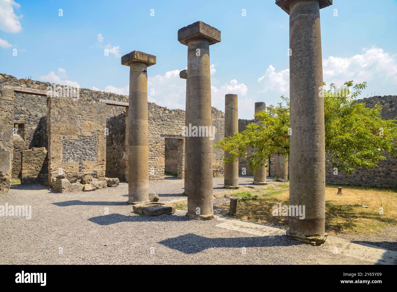 This captivating image displays the historical ruins at Pompeii, featuring ancient stone columns ...