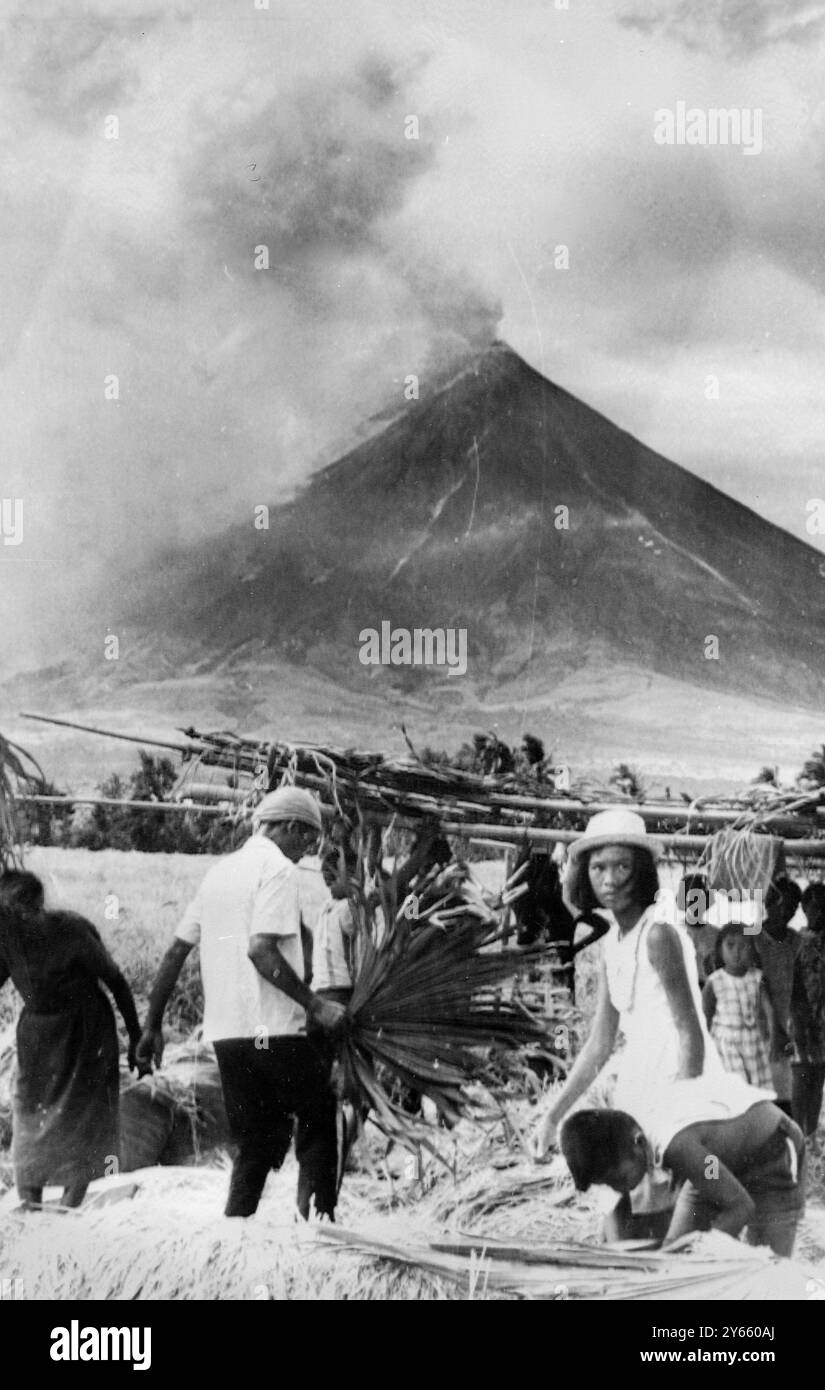At the foot of the volcano Mount Mayon , a farmer and his family , anxious about the damage to ...