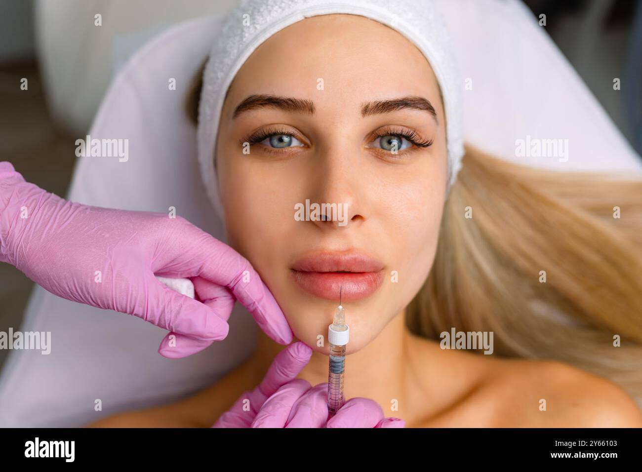 Injection procedure for lip augmentation, close-up. The cosmetologist ...