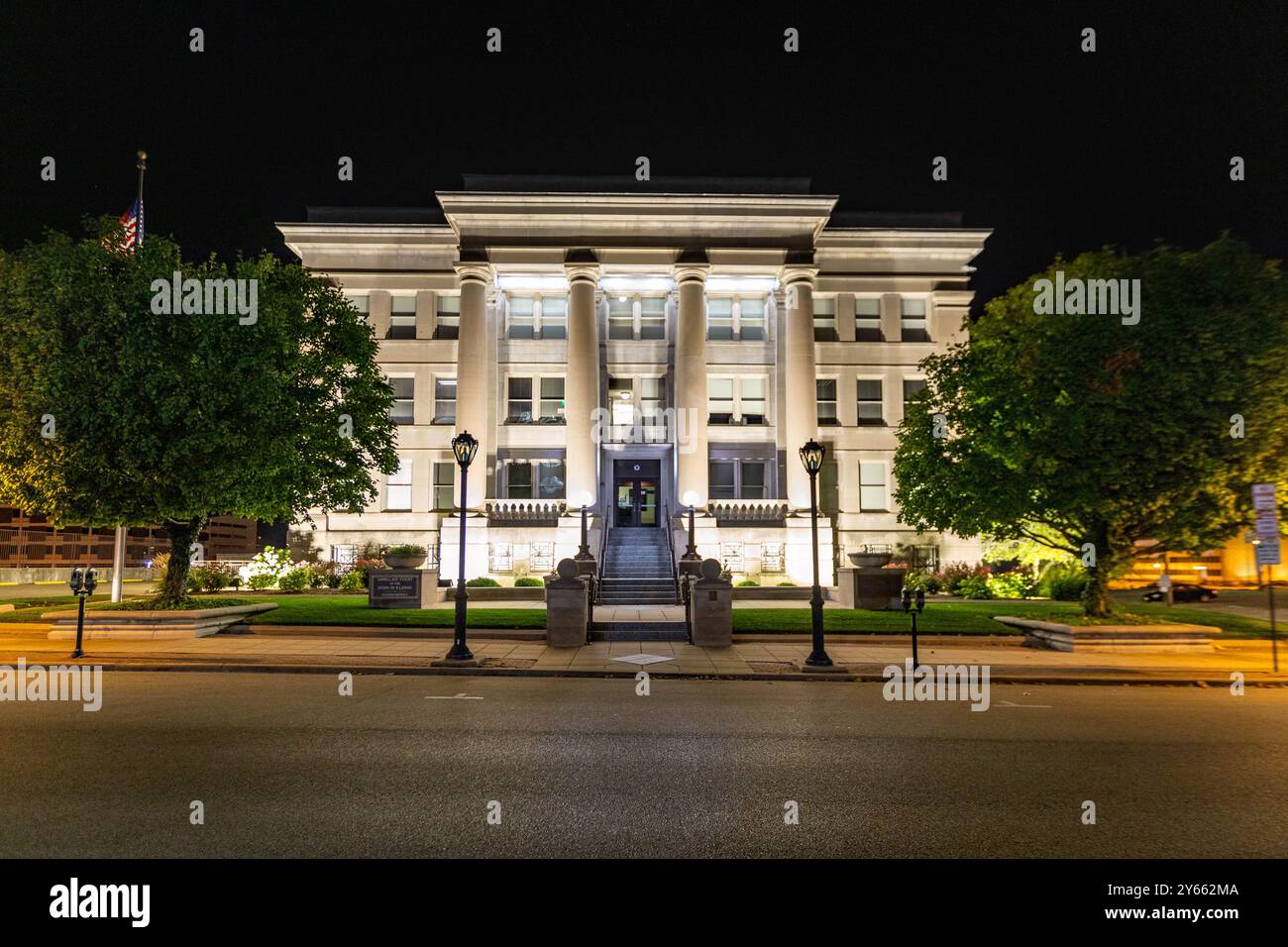 A night view of an illuminated courthouse building with classical ...