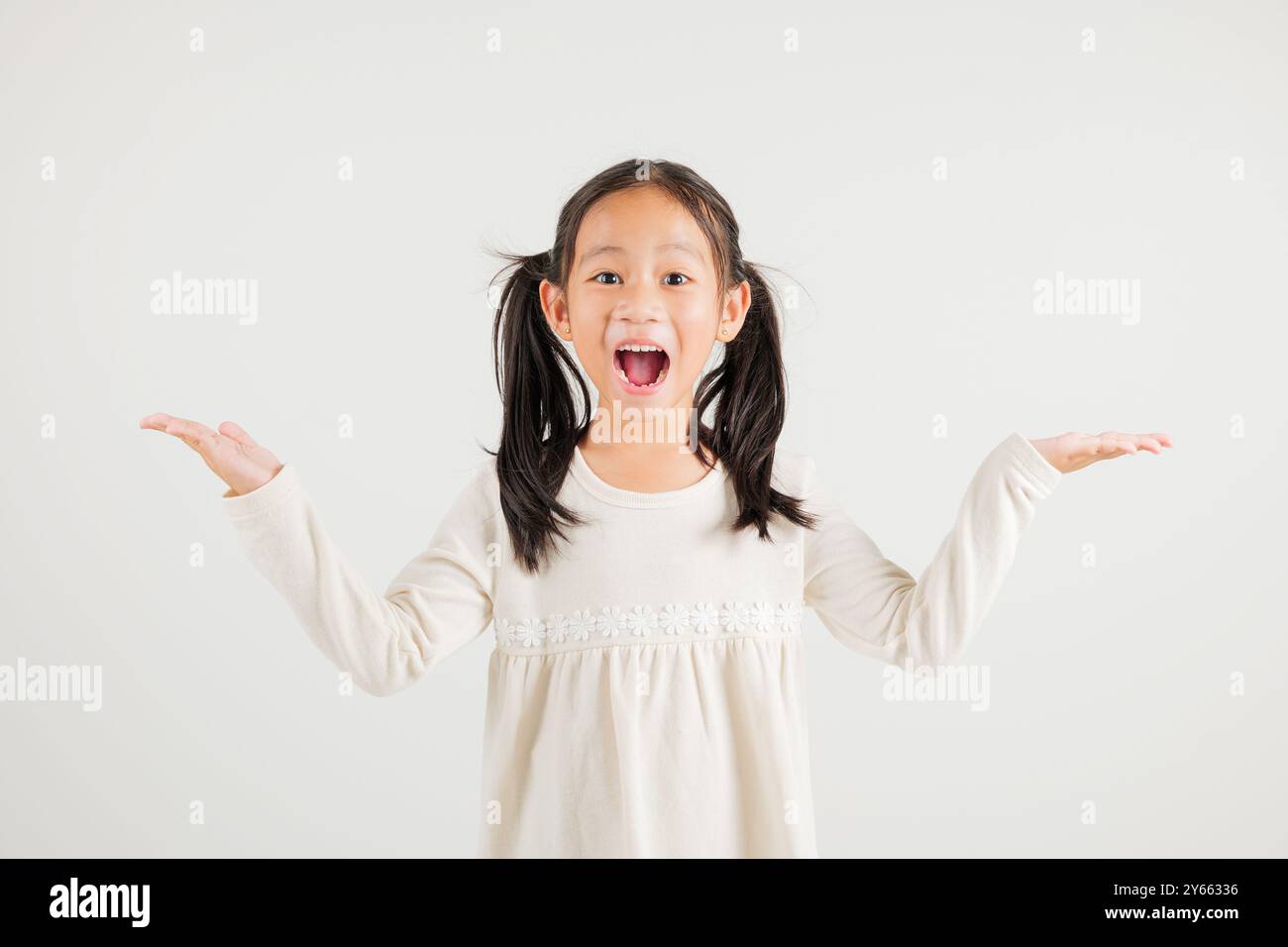 A jubilant kid girl raises her fists in celebration of her success ...