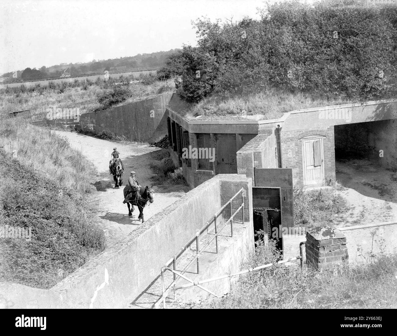 Farm workers ride work horses past an old Fort on Pedham Place farm at ...