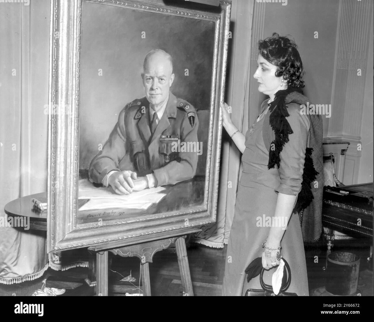 Lady Birley, wife of the late Sir Oswald Birley, admires a painting of ...