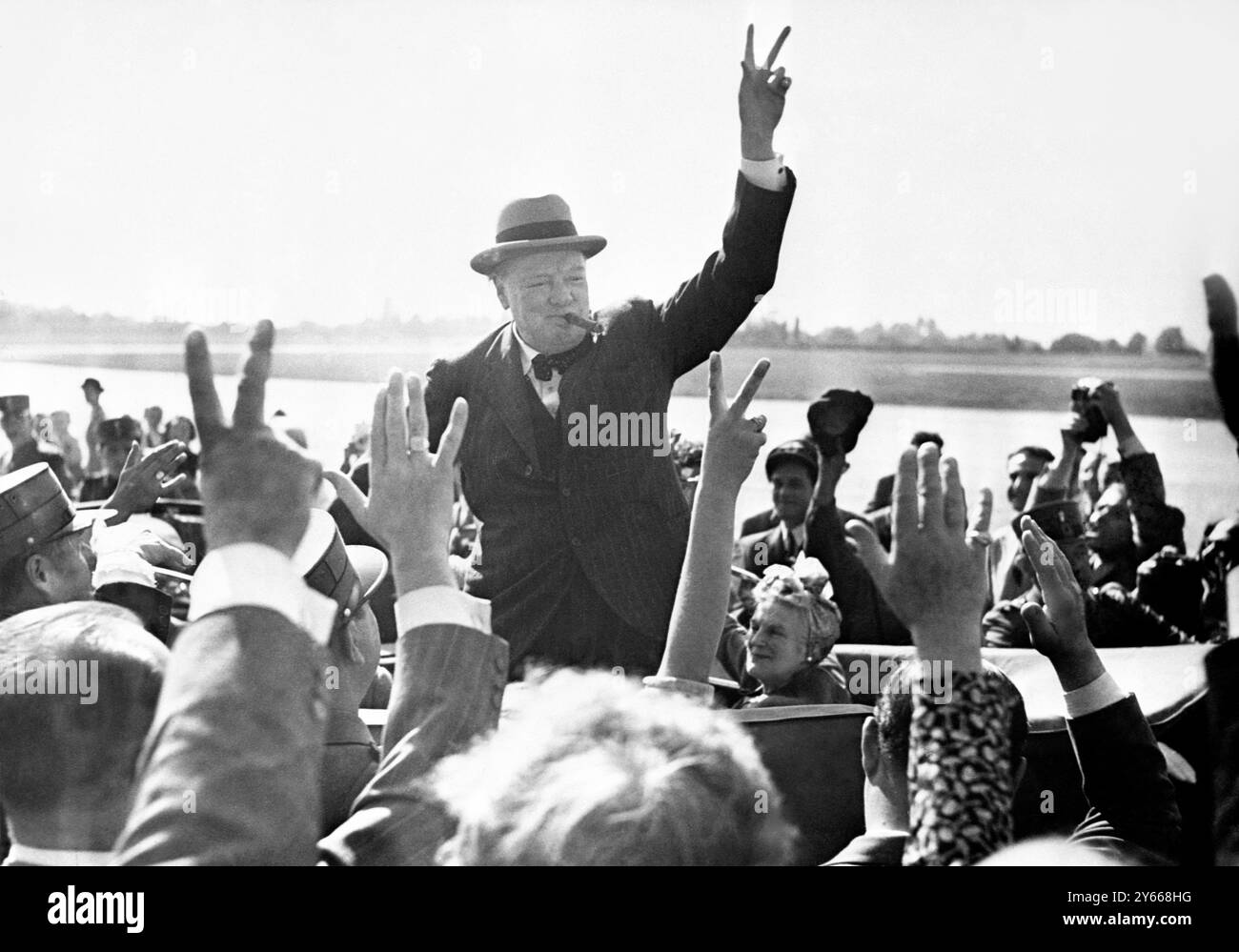 Mr Winston Churchill gives his famous V sign to the cheering crowds at ...