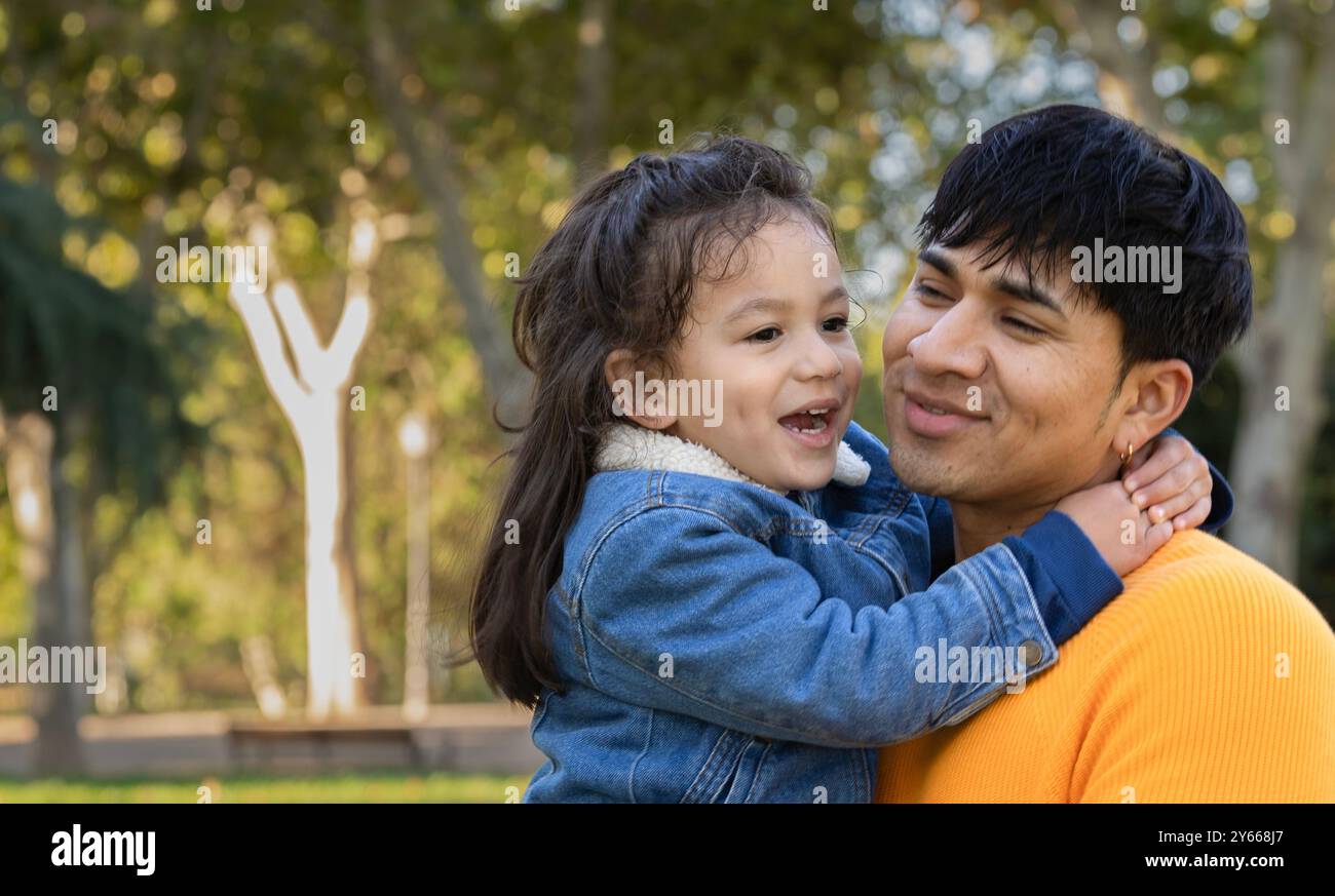 Headshot of happy hispanic father hugging and smiling with his son ...