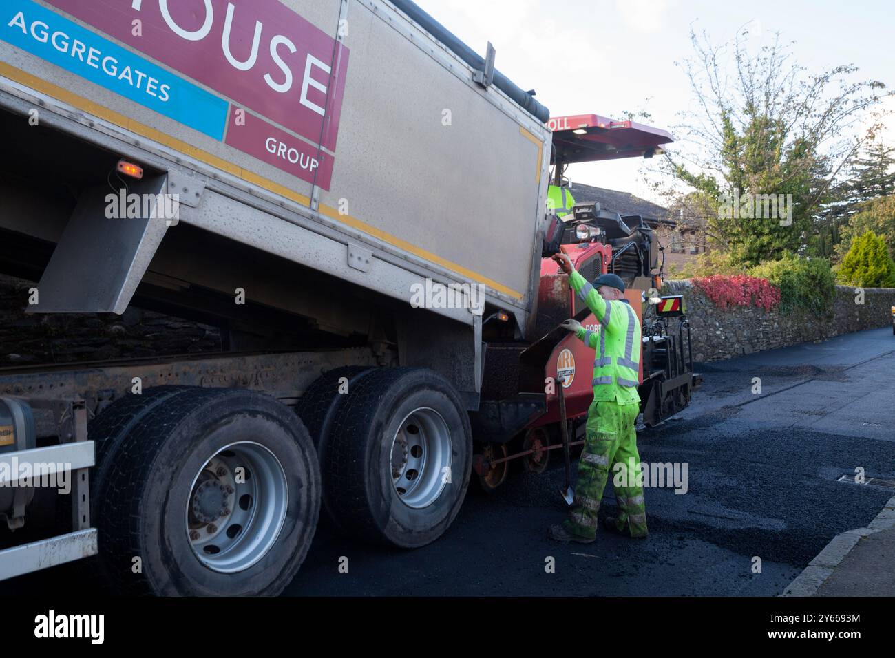 Workmen repairing road surface, Rhu, Scotland showing tar layer being ...
