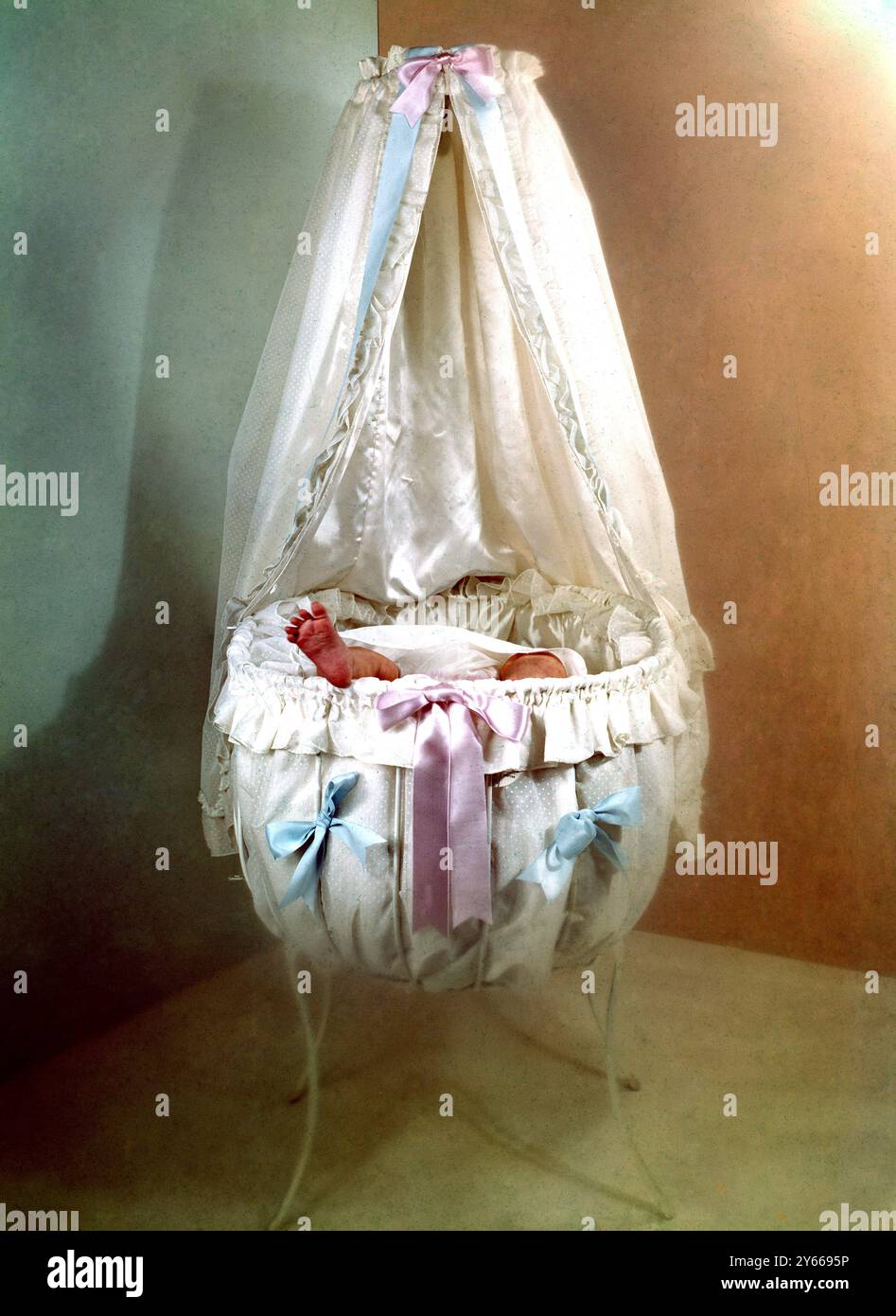 A beautifully decorated babys cot complete with lace and ribbons and ...