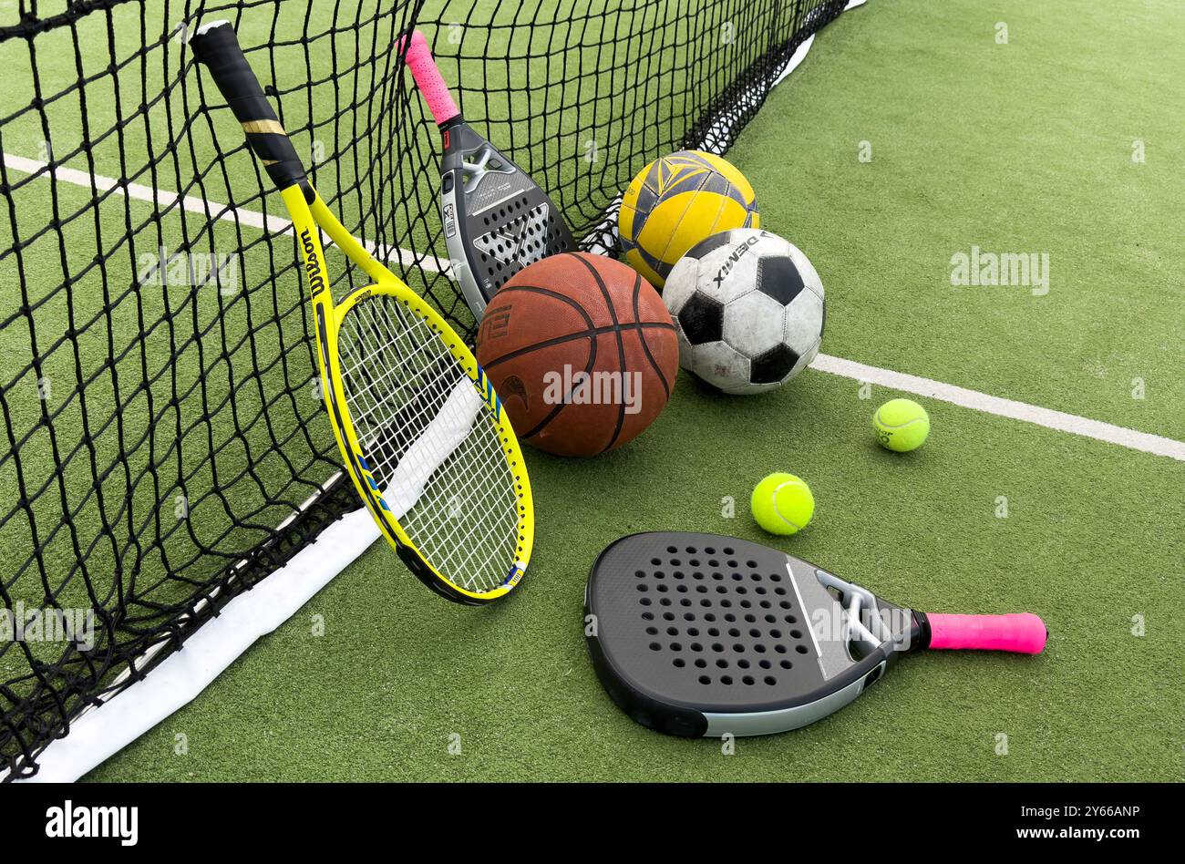 A set of various sports balls on the sports ground. A large orange ...