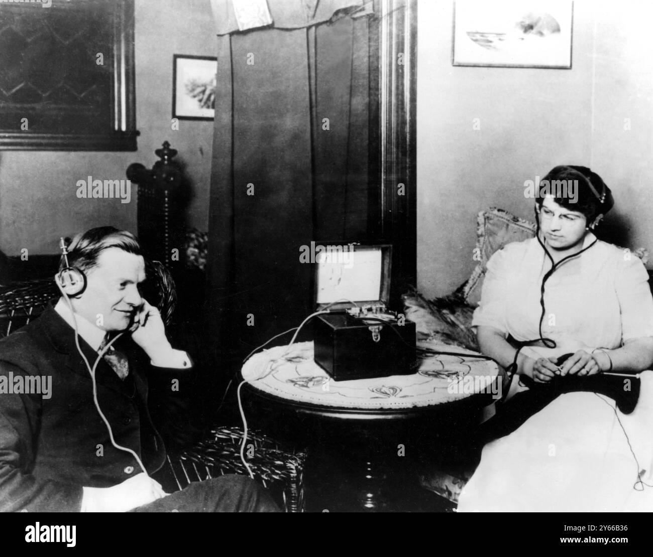 Mr and Mrs America wearing headphones, listen-in on a crystal set ...