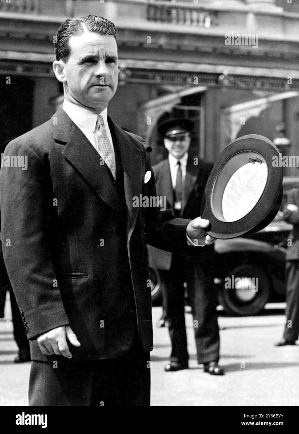 Sir Gordon Richards doffs his hat to the crowds as he leaves Buckingham ...
