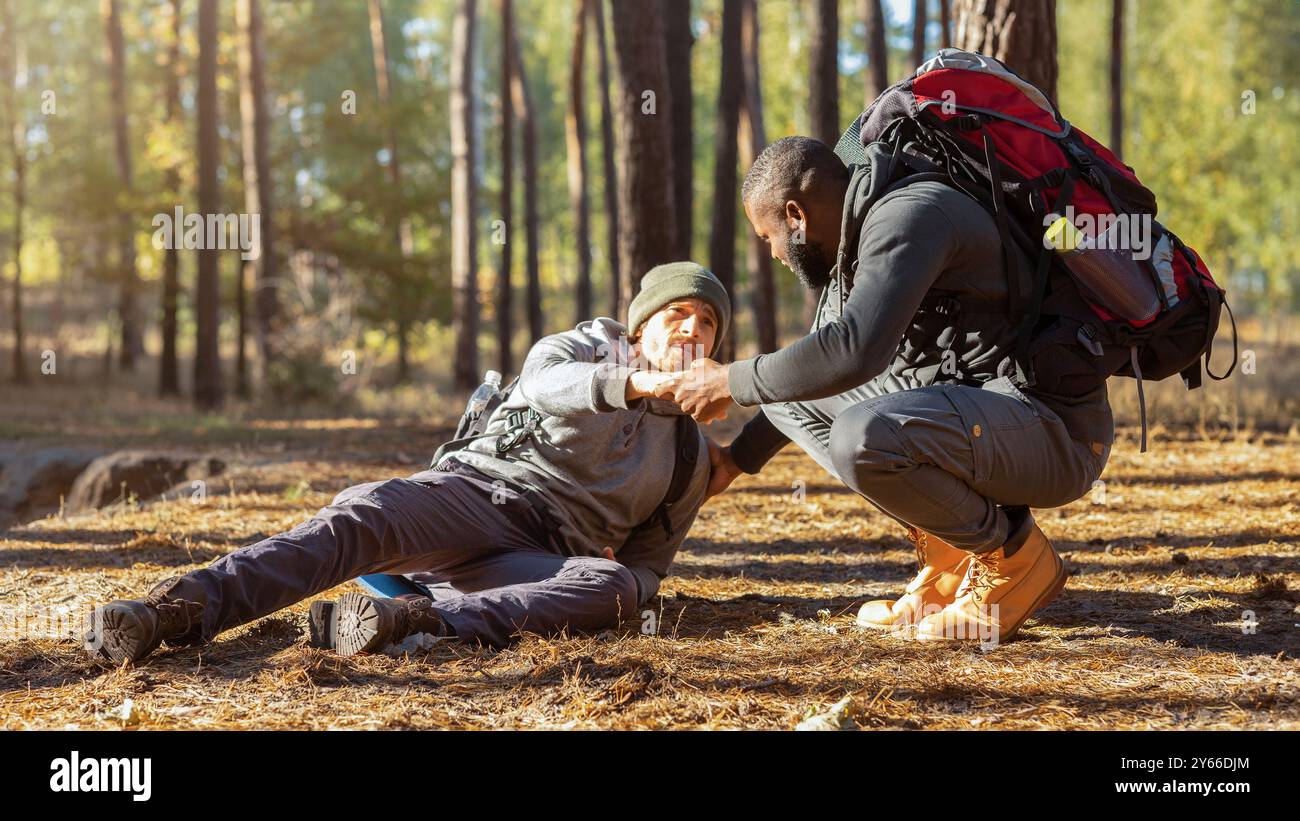 Black guy helping his injured friend to get up Stock Photo - Alamy