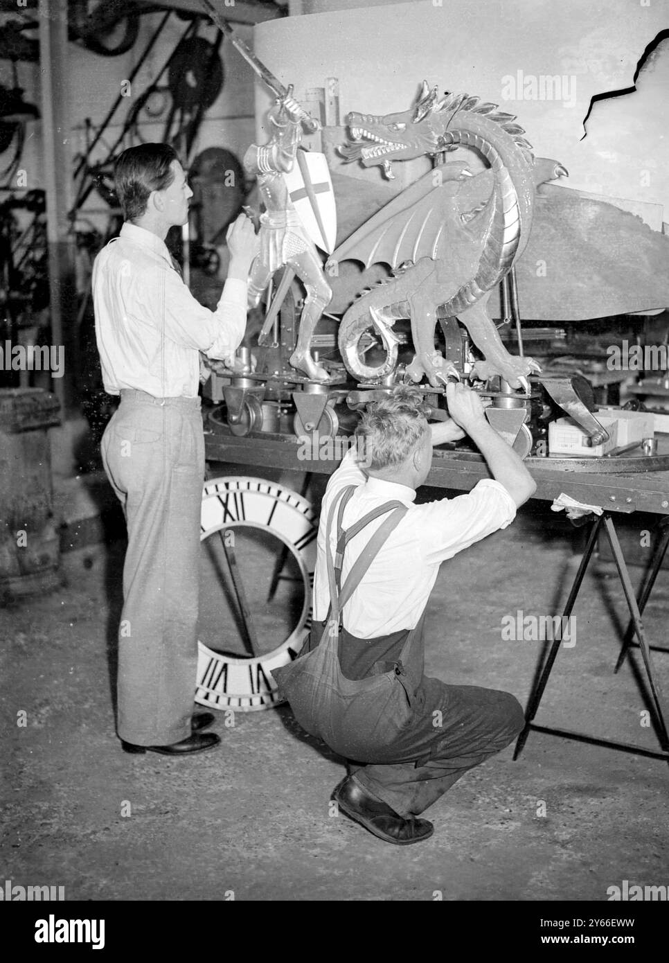 Men at work on the intricate mechanism of "St. George and the dragon ...