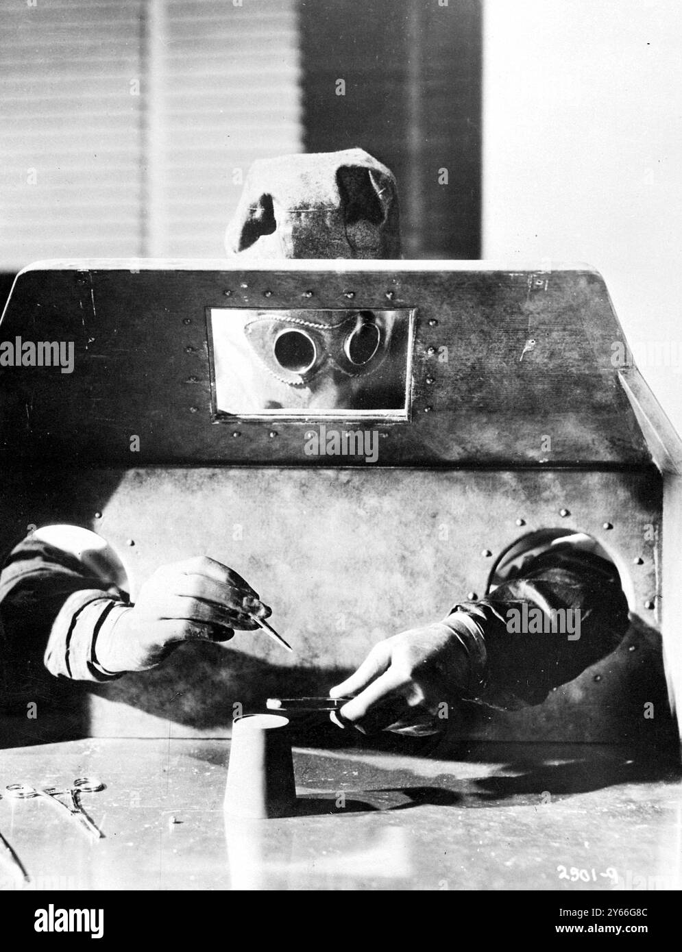 The scientist in his suit of protective material with a mask of lead ...