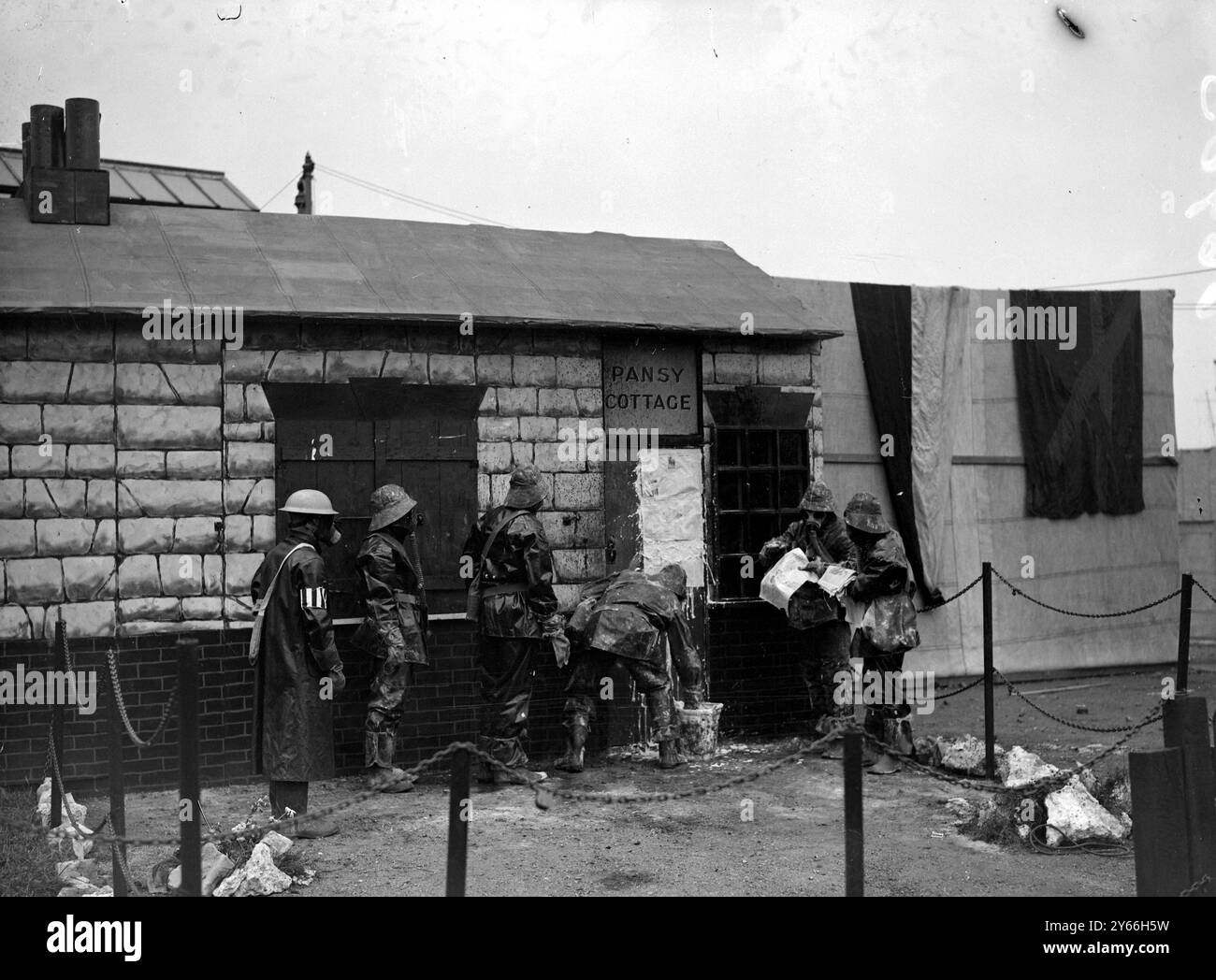 Men wearing masks and special clothing de contaminating a hut after the ...
