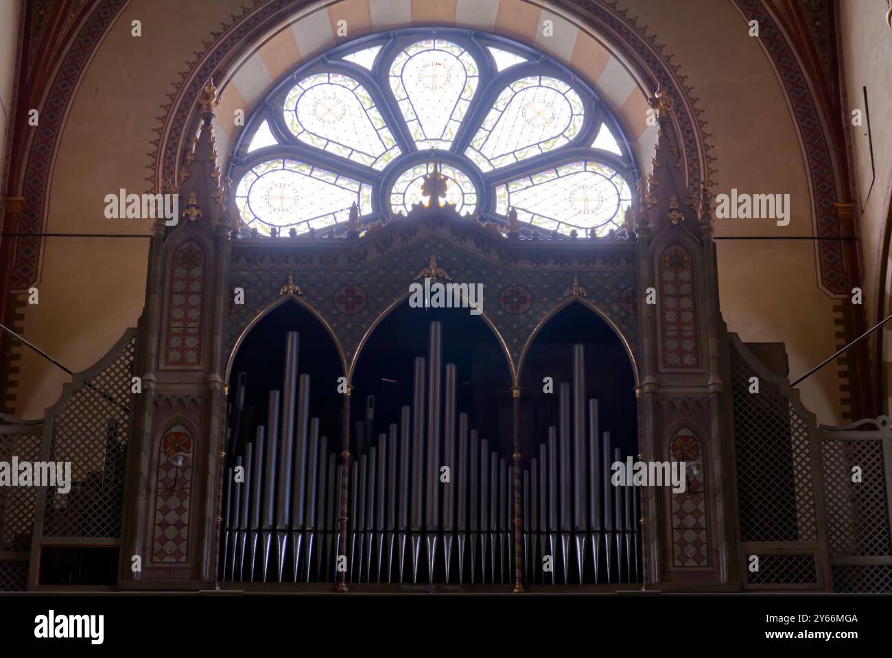 the pipe organ of a church under a rose window full of light Stock ...