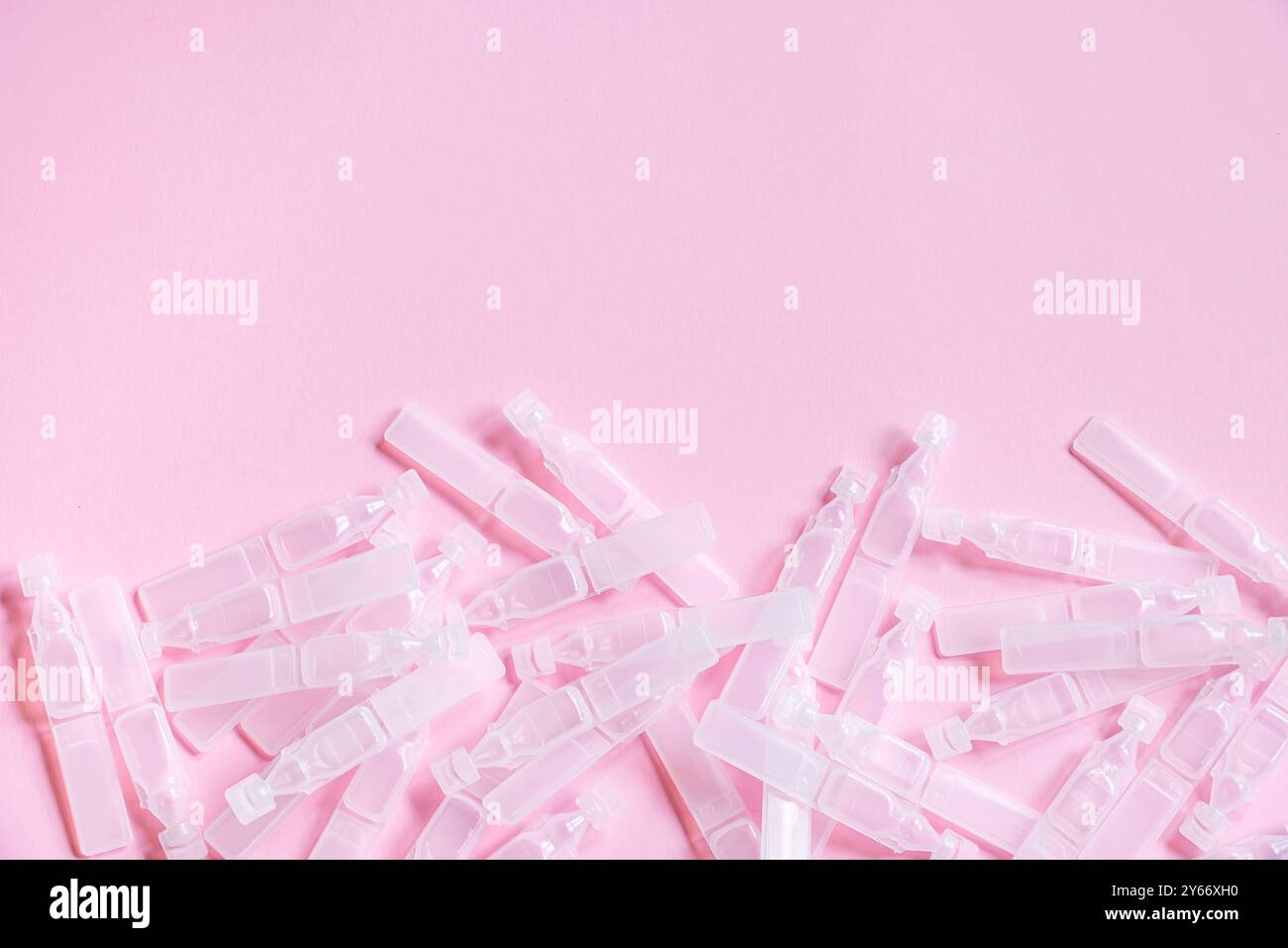 Medical eye drops in plastic pipettes on pink background. Pile of empty ...