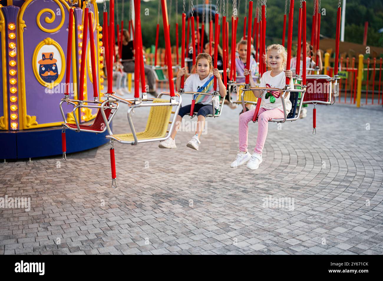 Group of happy children having fun on a carousel swing ride in an ...