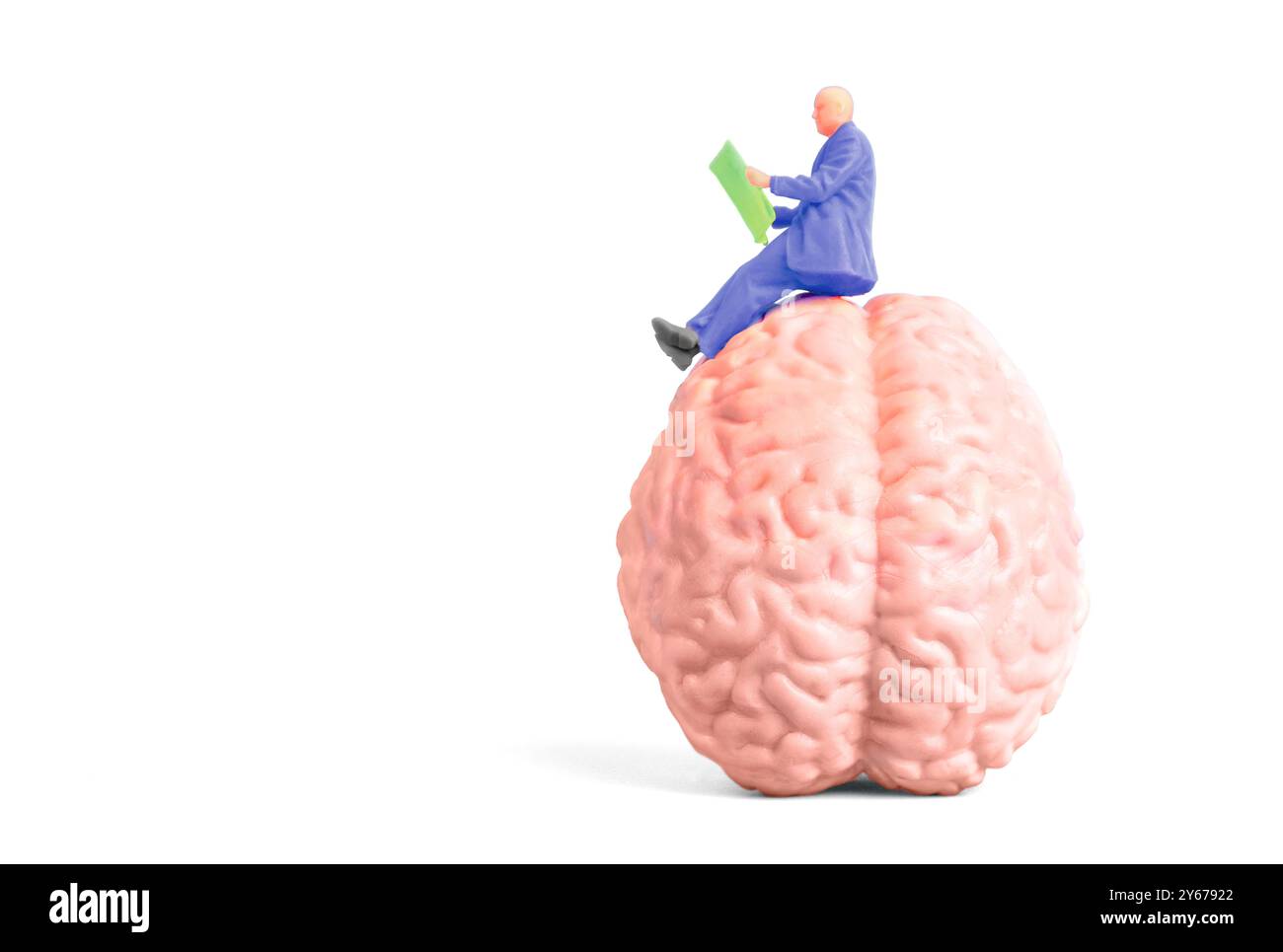 Miniature figure of a businessman in a blue suit reading paperwork ...