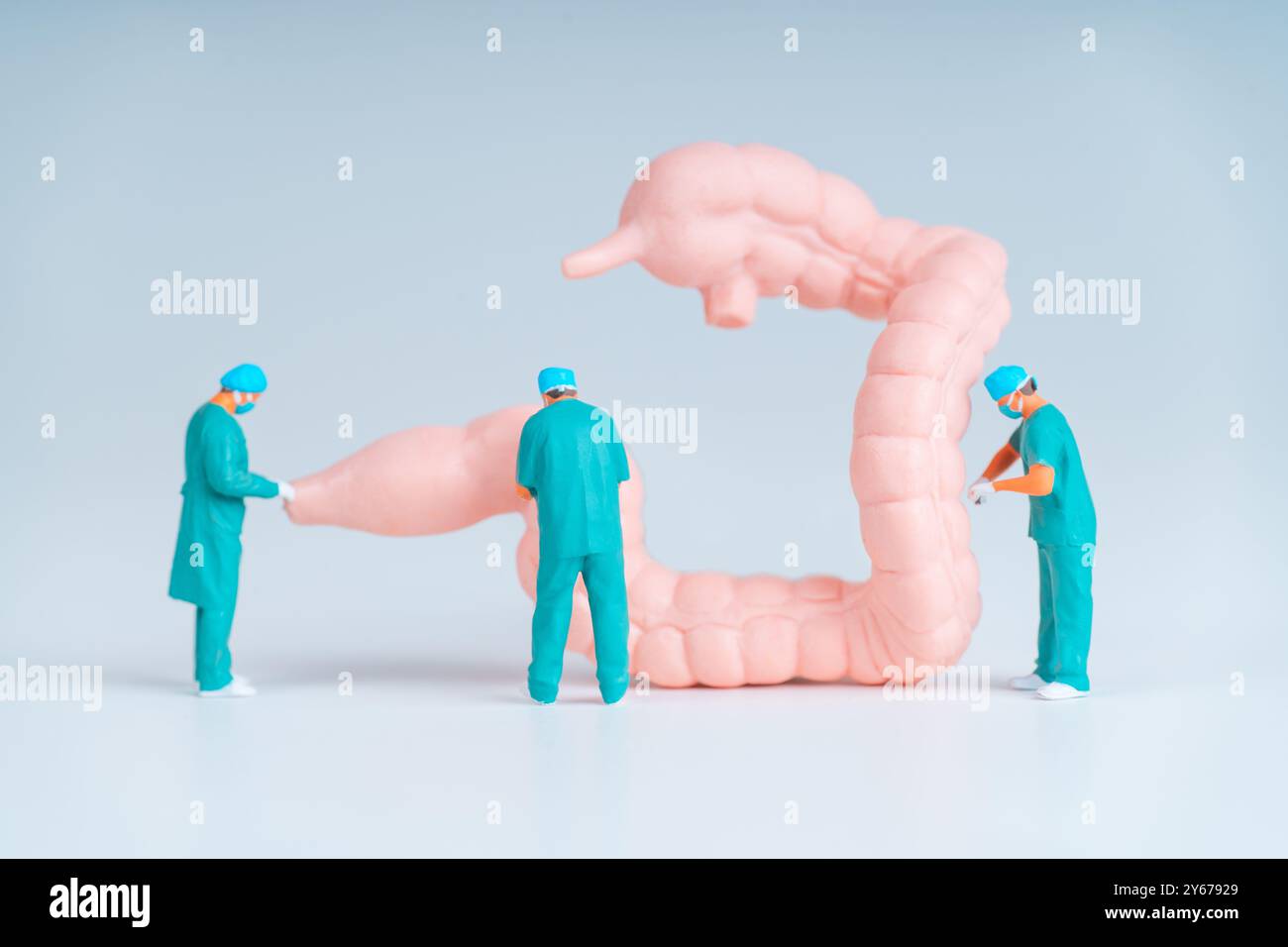 Three surgeons examining a large anatomical model of the human ...