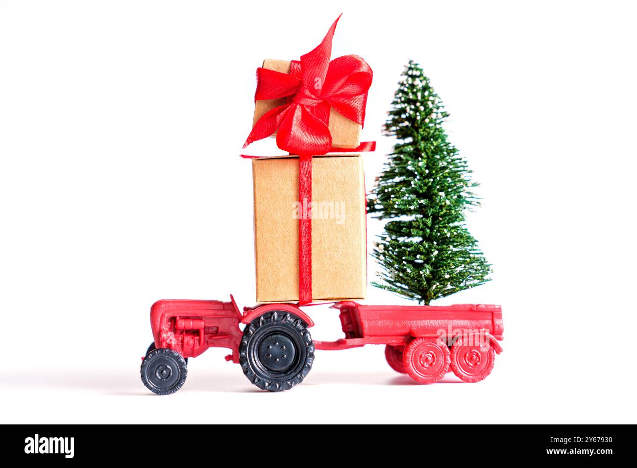 Whimsical red tractor carrying wrapped presents and a Christmas tree ...