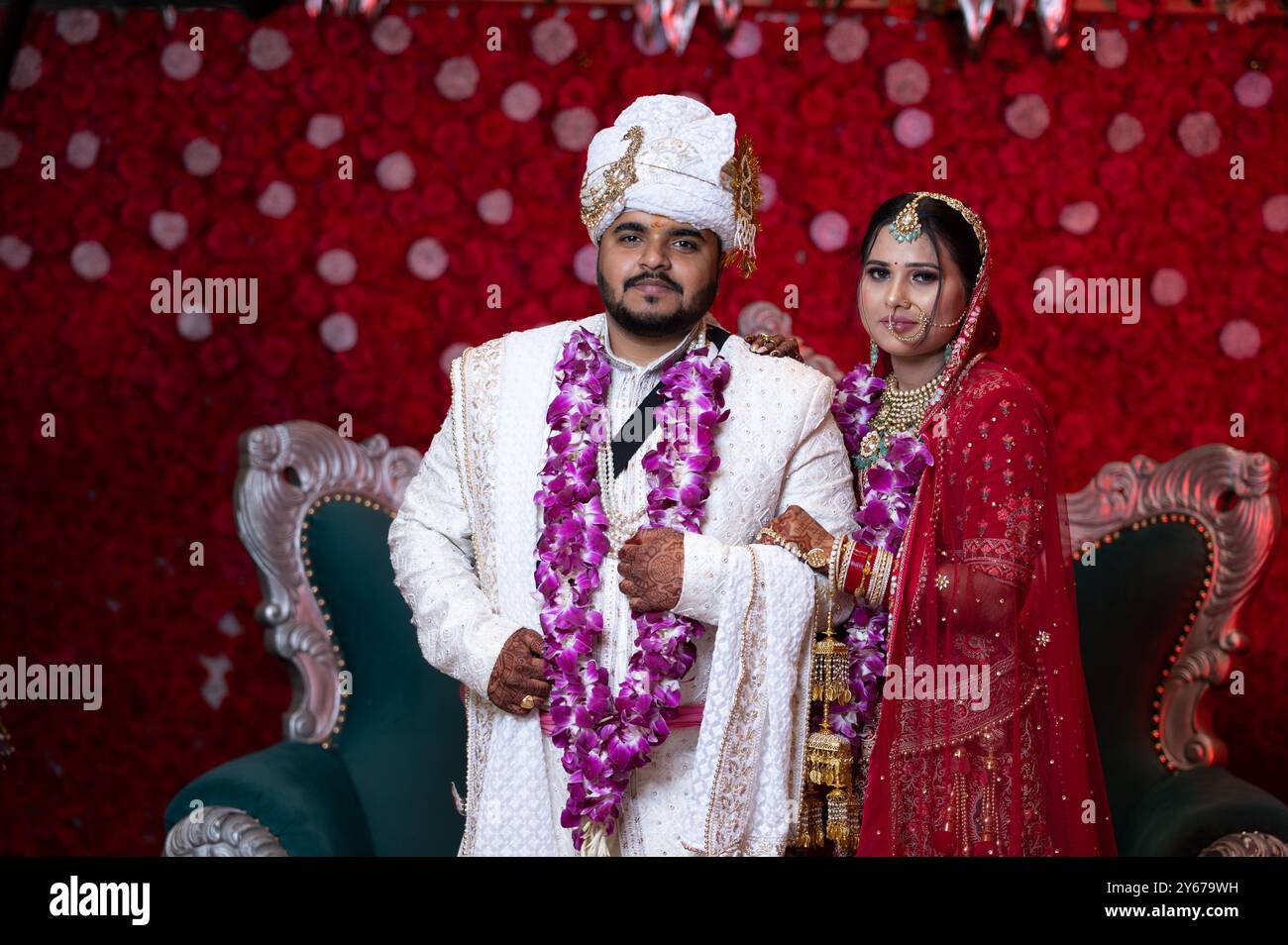 A newlywed couple in traditional Indian attire posing during their ...