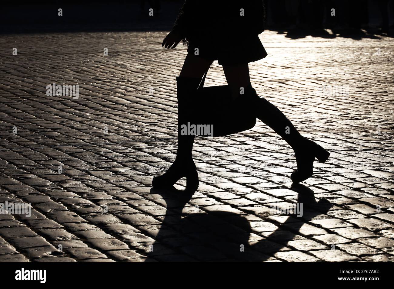 Black silhouette and shadow of slim girl walking on city street. Female ...