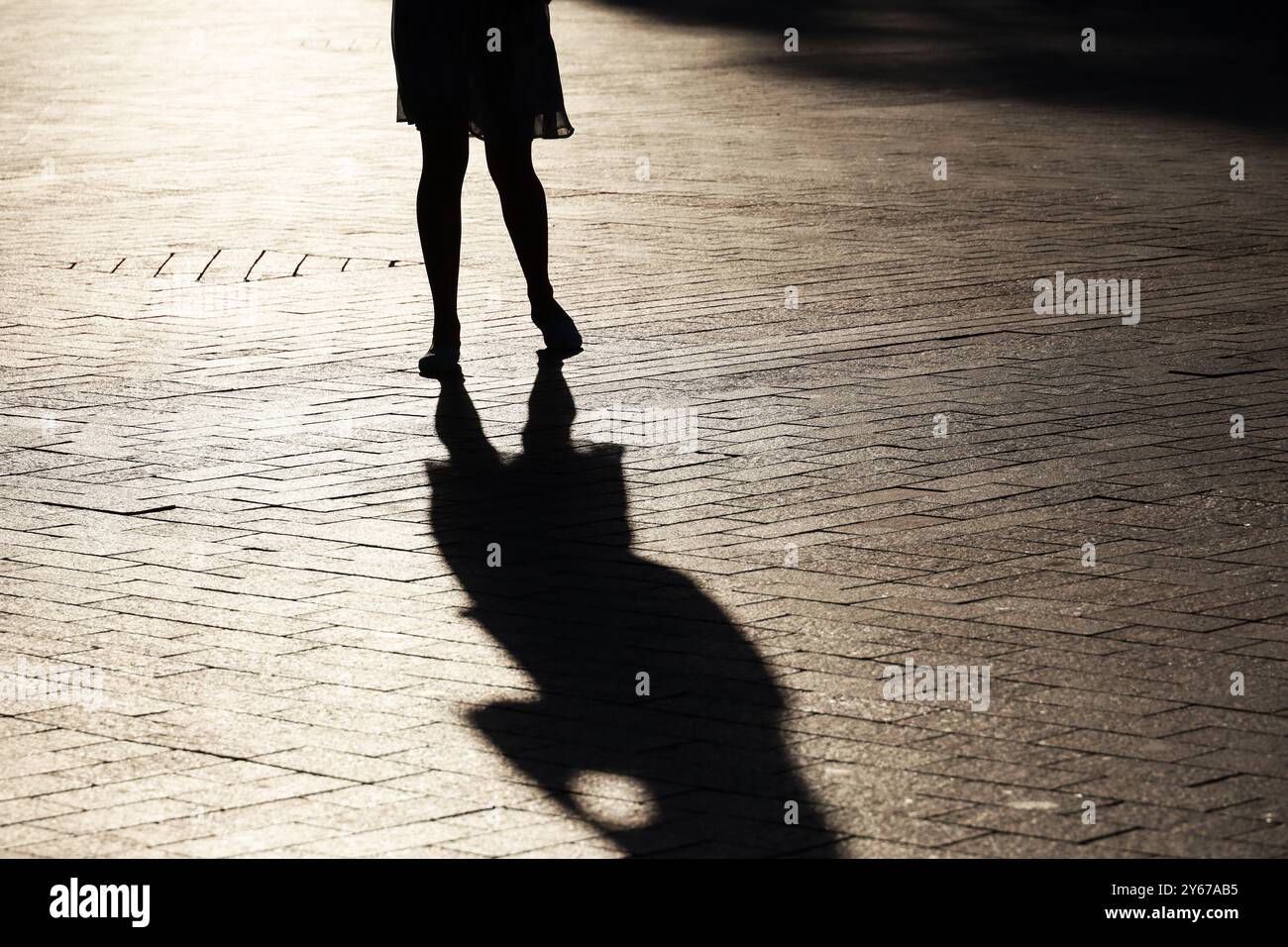 Black silhouette and shadow of lonely slim woman walking on a street ...