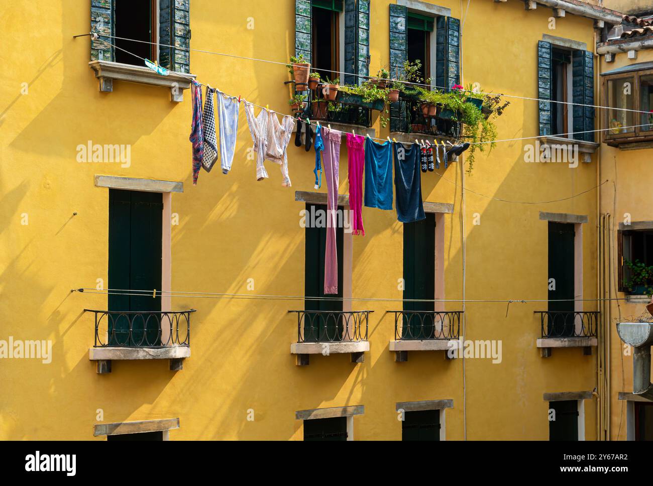 Washing hanging out to dry on a washing line suspended between two ...