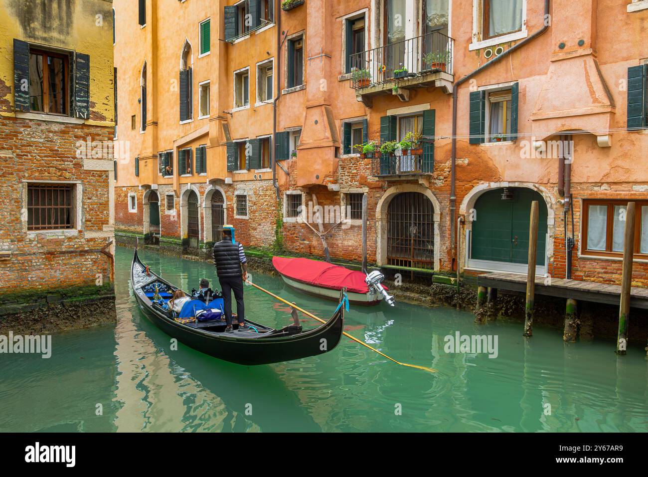 A gondolier steers his gondola along a rio de San Lio a canal in the ...