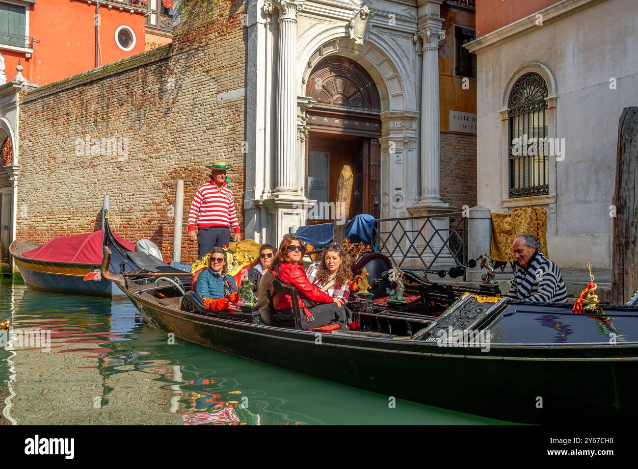 A group of people taking a gondola ride on Rio de San Zulian a canal in ...