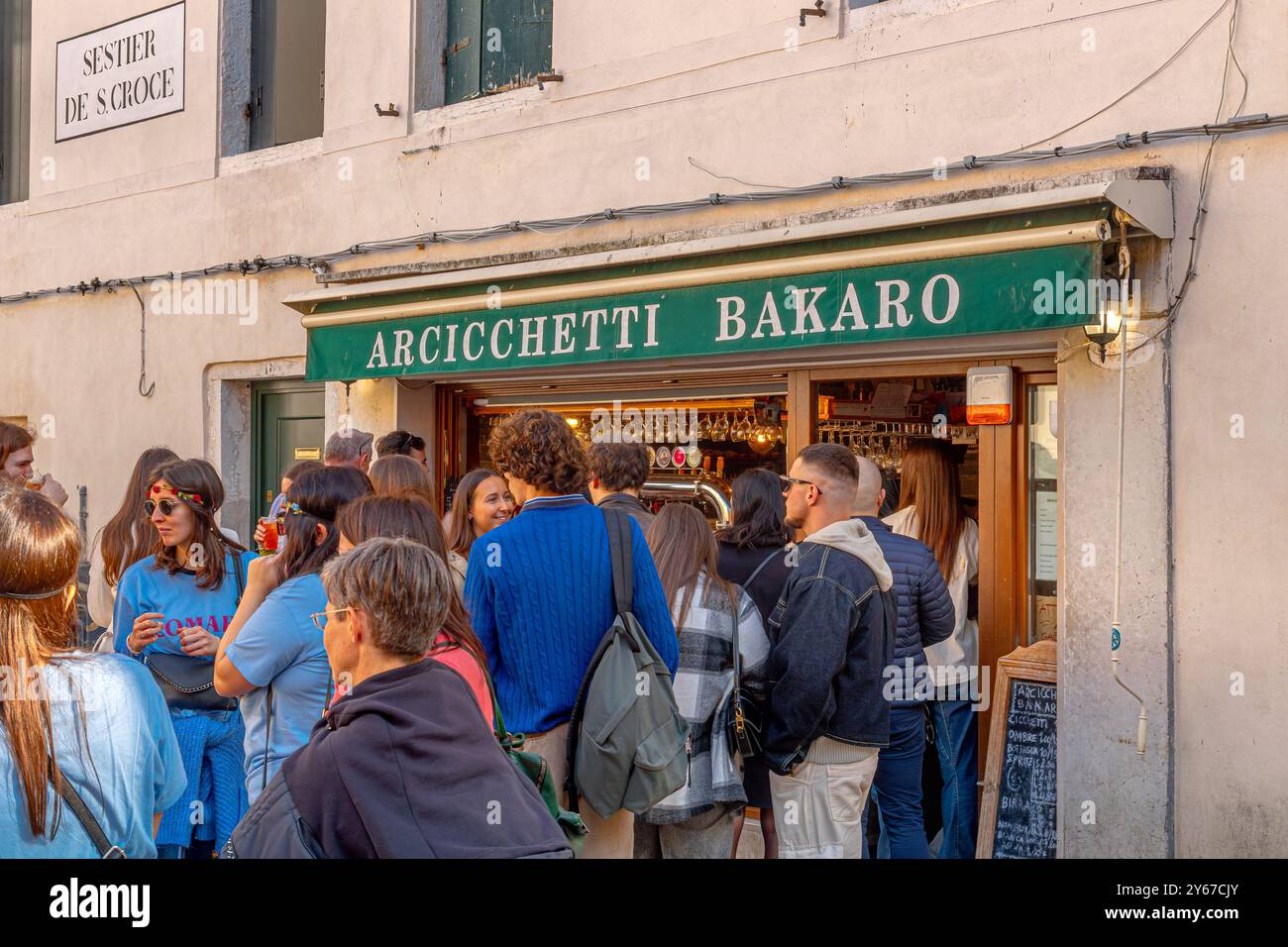 A line of people queuing outside Arcicchetto Bakaro a popular wine bar ...