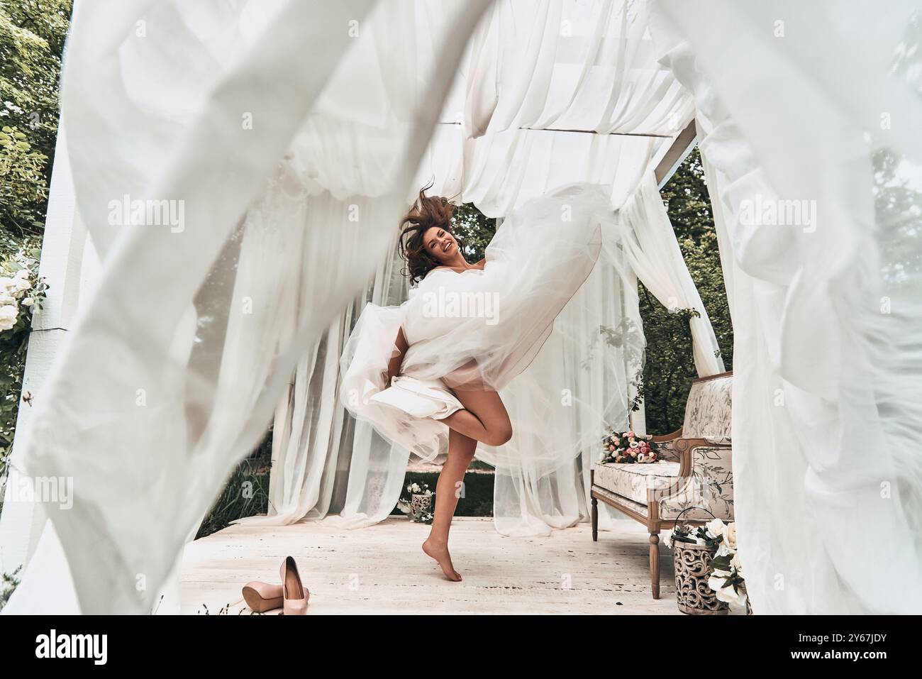 Playful bride. Full length of attractive young woman in wedding dress ...