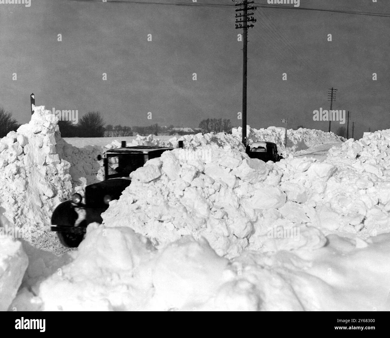 Heavy winter snow drifts blocked many roads as shown here. 1940's Stock ...