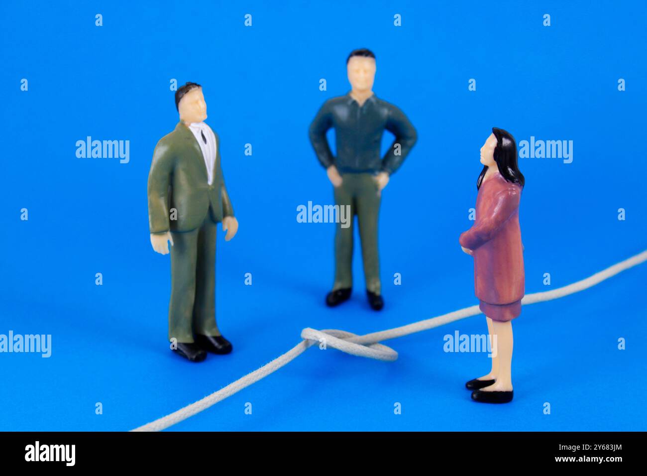 Team gathered to untie rope with knot that represents a work conflict ...