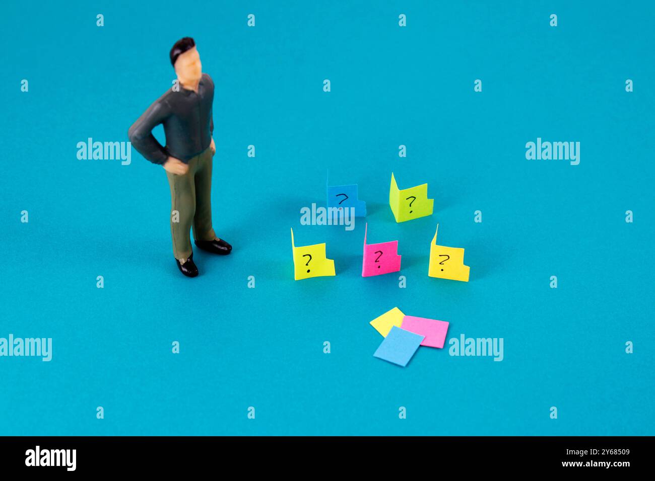 Executive next to group of documents and colorful folders with question ...