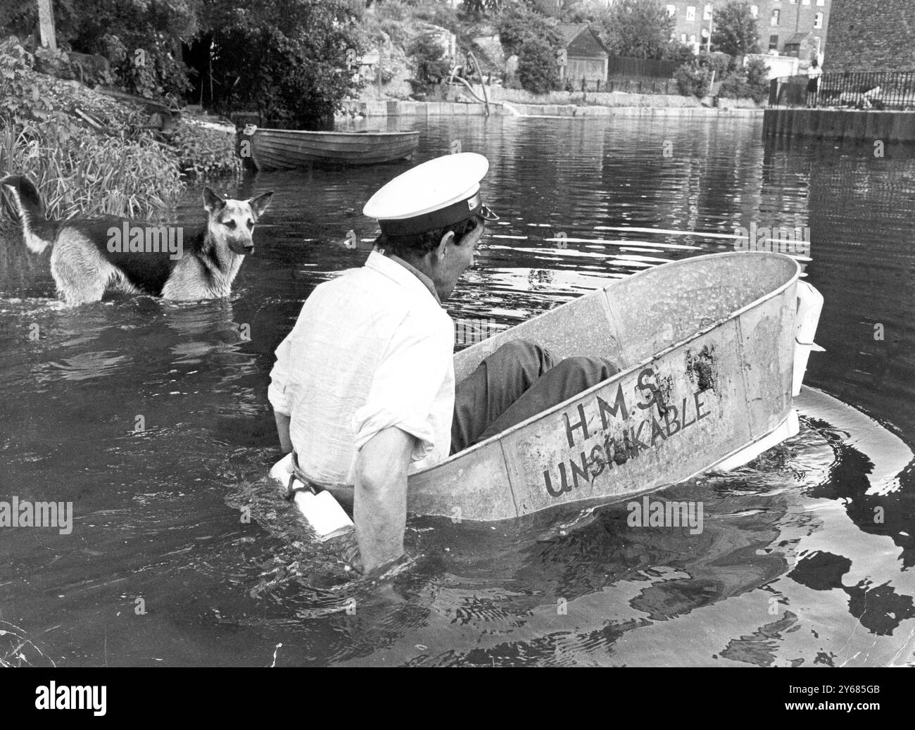 Man floating in a tin bath tub called HMS Unsinkable, in a river ...