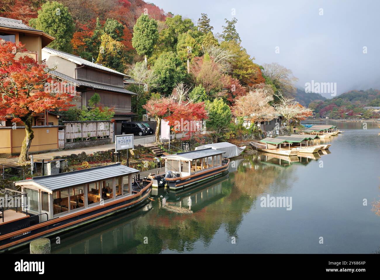 Scenic view of traditional Japanese boats docked along a river with ...