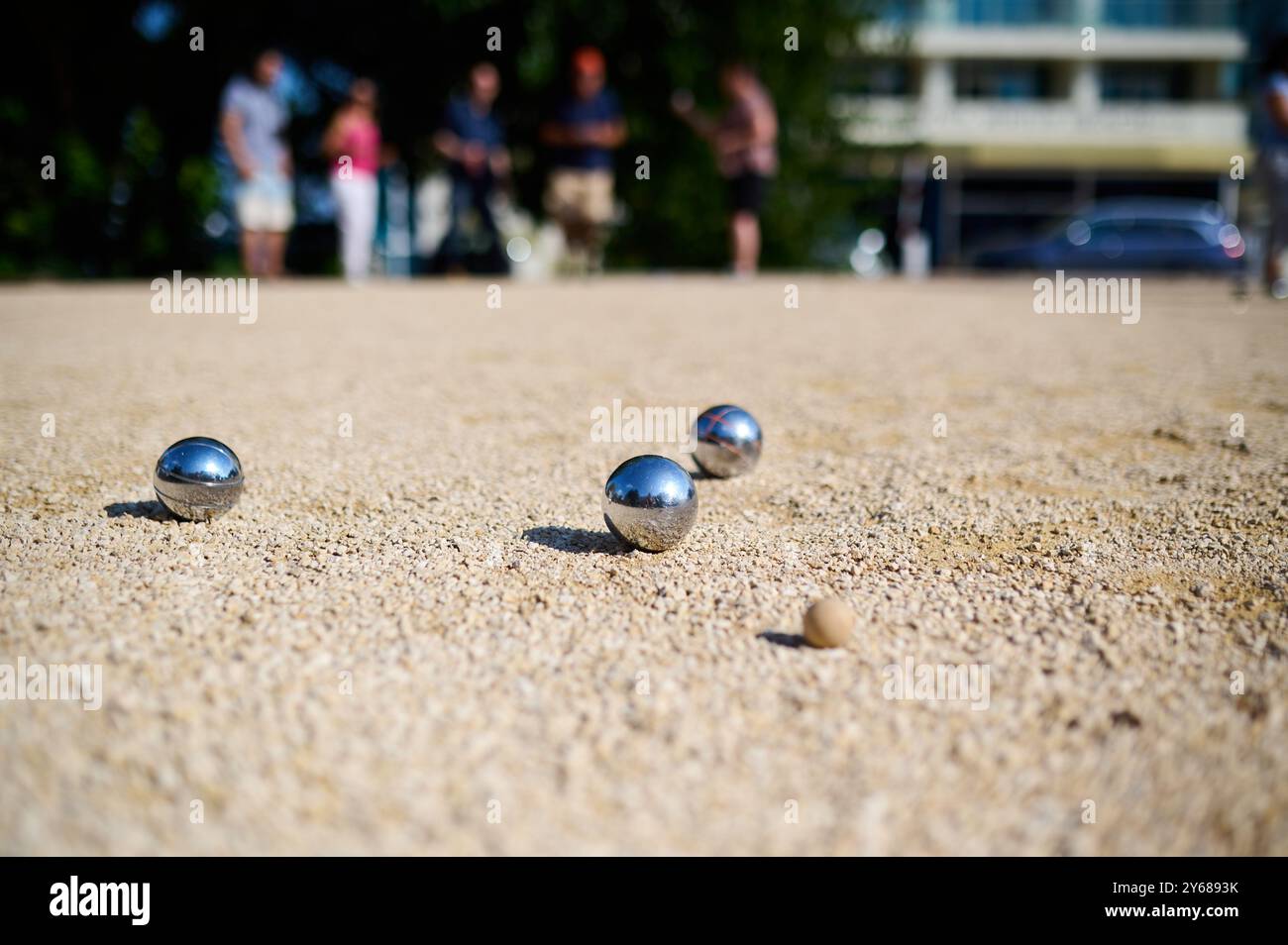 Close-up of petanque balls scattered on gravel with the target ball in ...