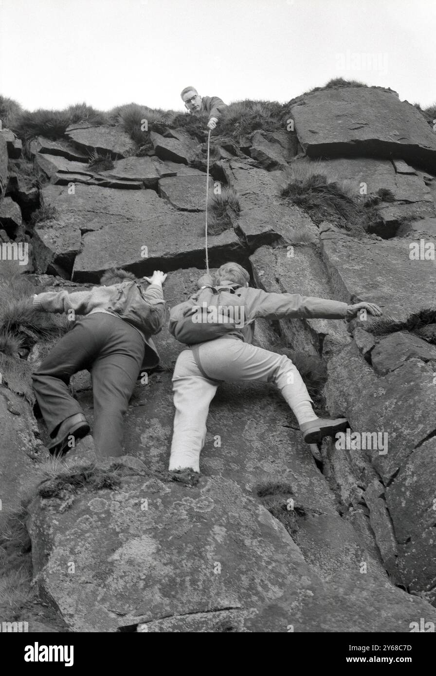 1950s, historical, rock climbing, two people on a cliff-face, on ...