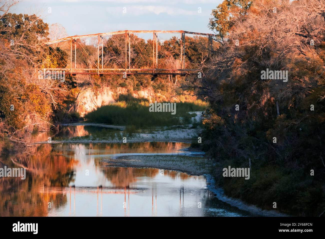 Arched bridge spanning a gently flowing river, capturing the reflection ...