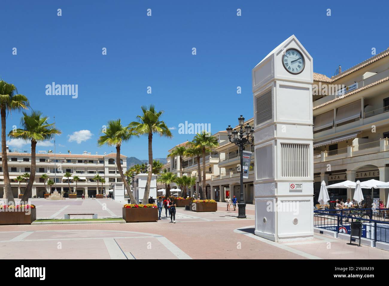 Modern square with clock tower and palm trees under a blue sky, Plaza ...