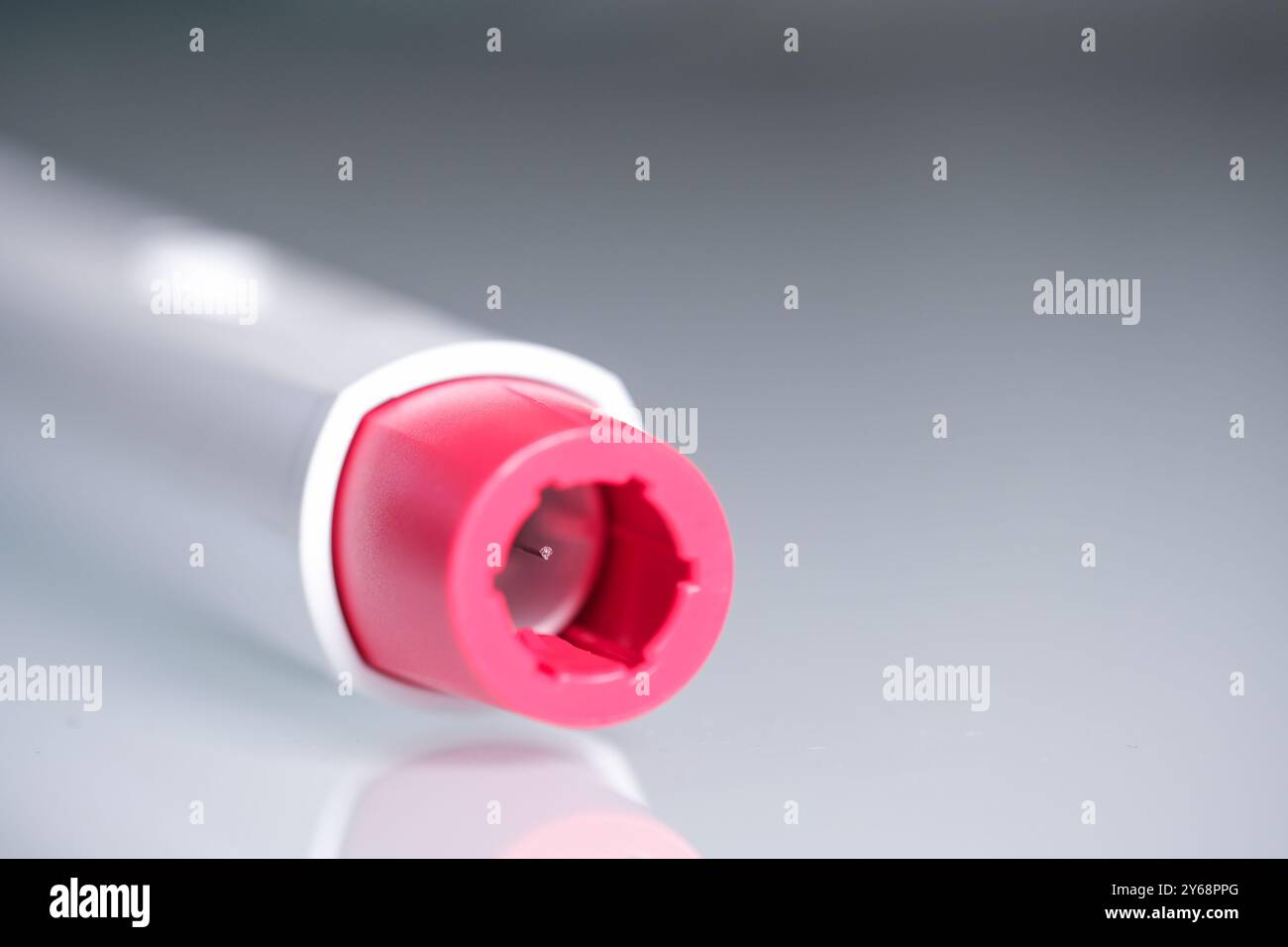 Detail of the head of a pen injector with a red tip for biological ...