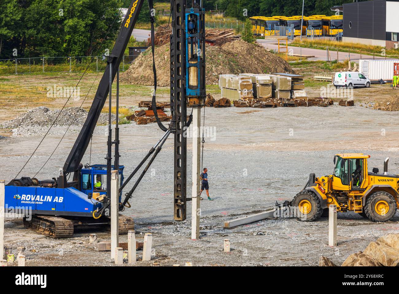 Construction site with pile driver and excavator at foundation work ...