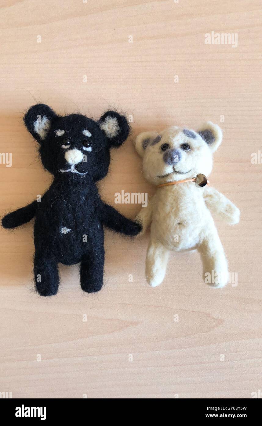 Adorable felt teddy bears on light wooden table. Handmade eco toy ...