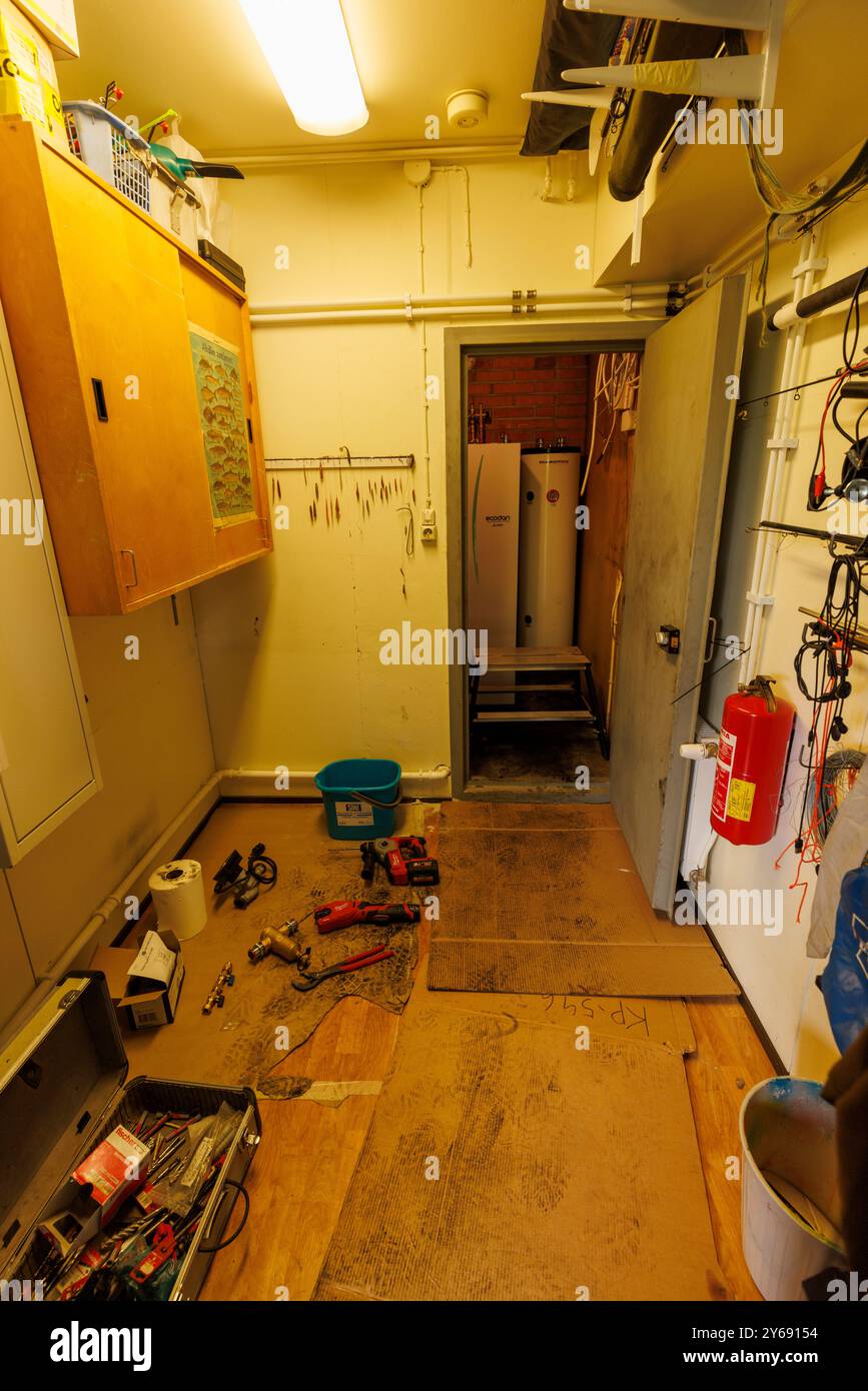 Tools and work site indoors, replacing old oil boiler with air to water ...