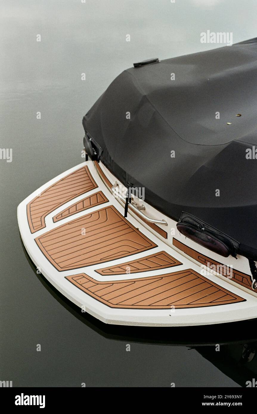 Minimal retro film shot of motor boat covered by protective tent with ...