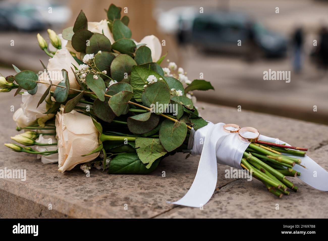 Elegant wedding bouquet featuring pale roses, eucalyptus, and entwined ...